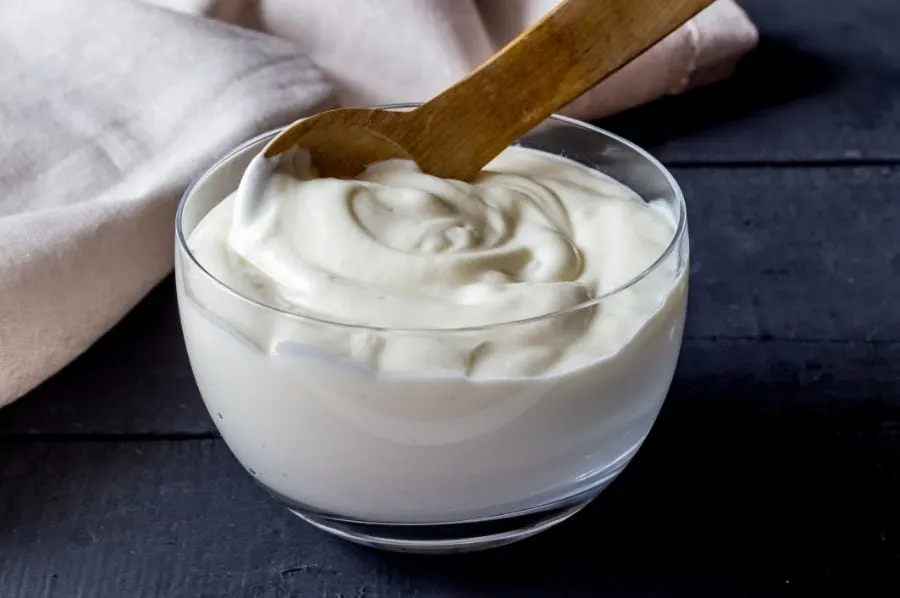 How do you add yogurt to sauce without curdling?