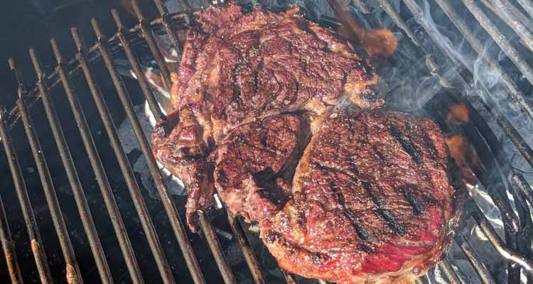 How do you cook a thin ribeye steak on a charcoal grill?