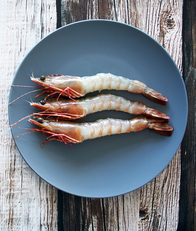 How do you hold prawns in place when cooking?