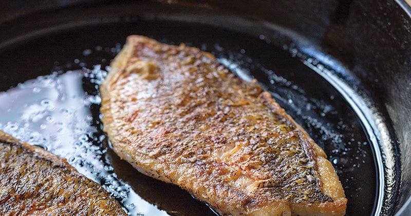 How do you keep fish from curling when frying?