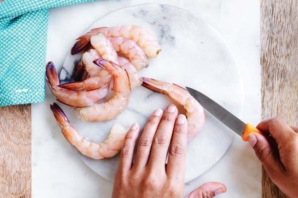 How do you poach prawns before cooking?