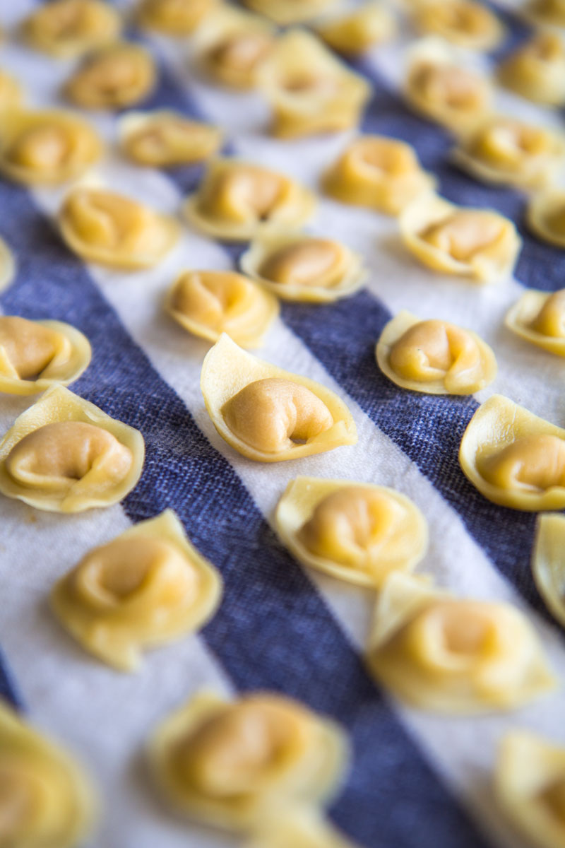 How is tortellini traditionally served?