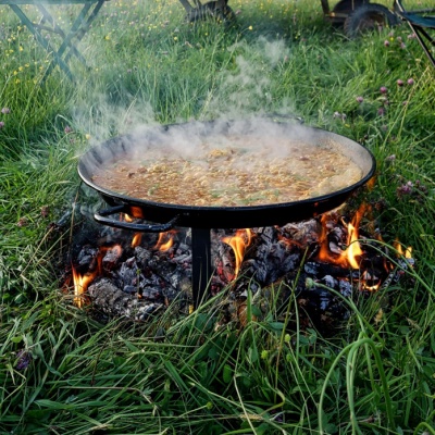 Is paella cooked over a fire?