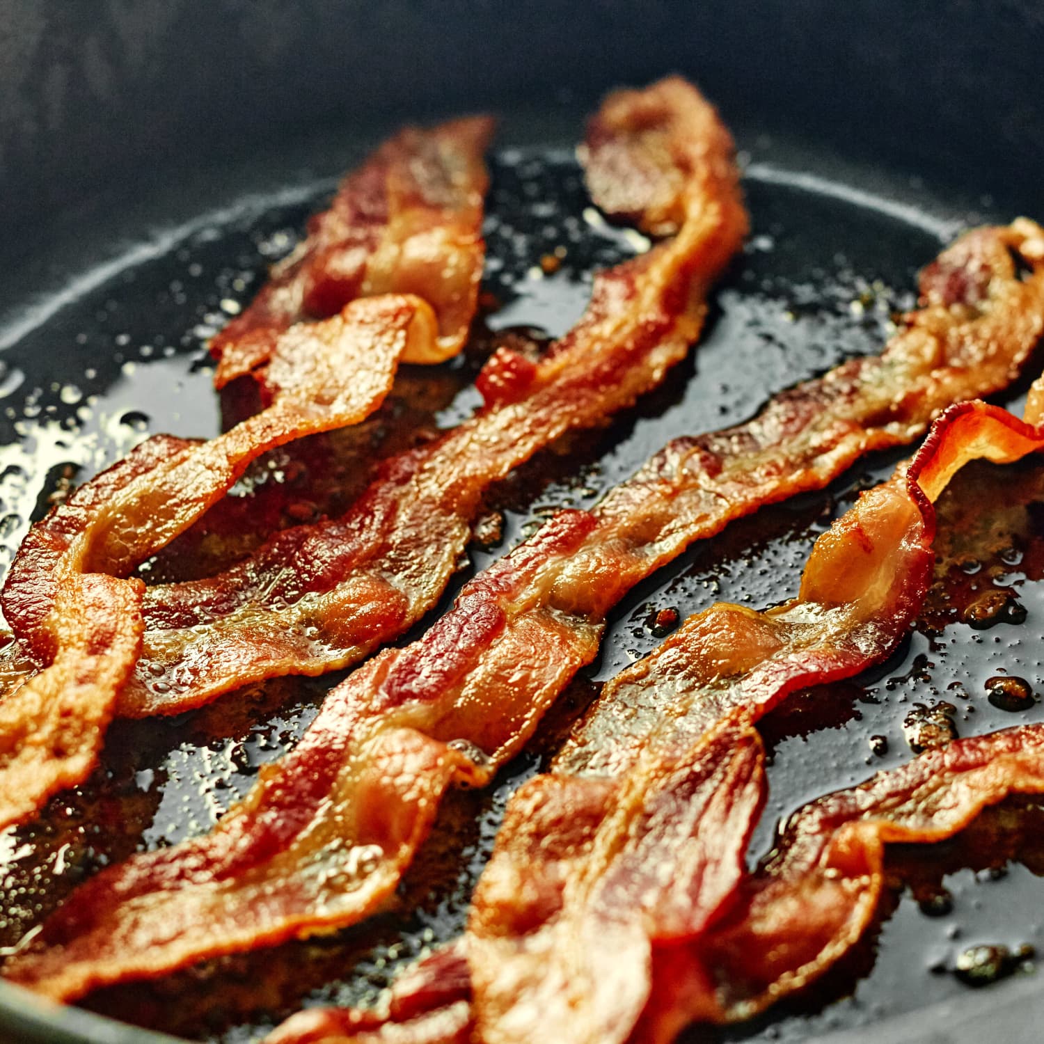 What do you put on the pan before cooking bacon?