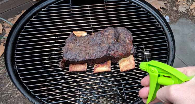 What do you spray meat with when smoking?