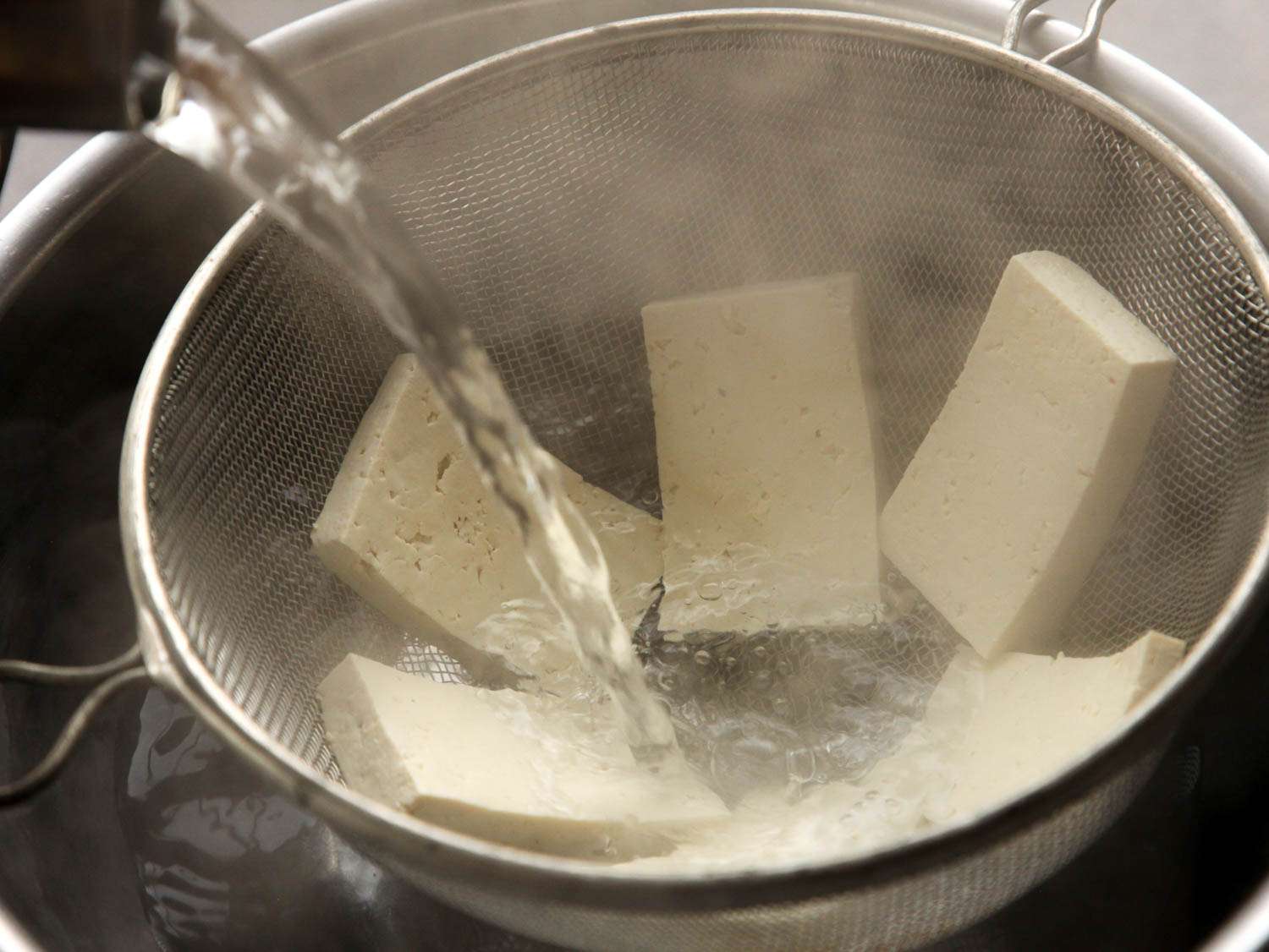 What does pouring boiling water on tofu do?