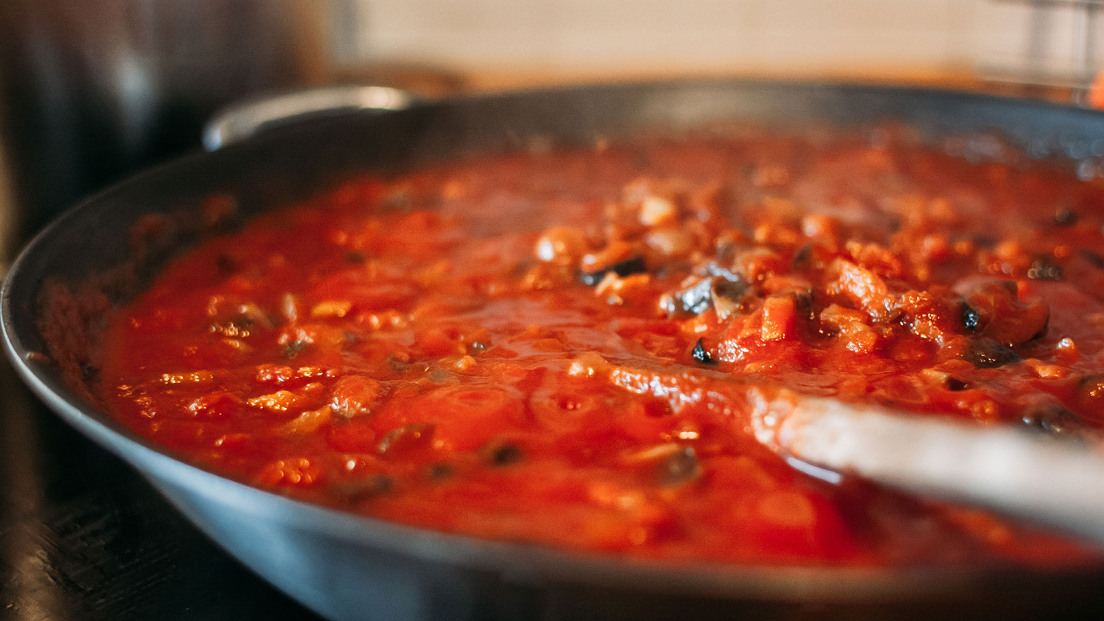 What is the main method used to thicken a tomato sauce?