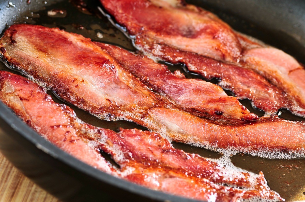 Why does bacon curl up when cooking?